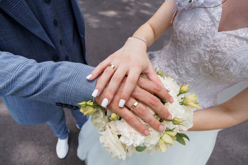 A Romantic Wedding Moment with Intertwined Hands and Floral Bouquet ...