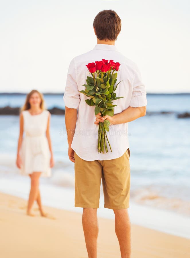 Romantic Young Couple In Love Man Holding Surprise Bouquet Of R Stock