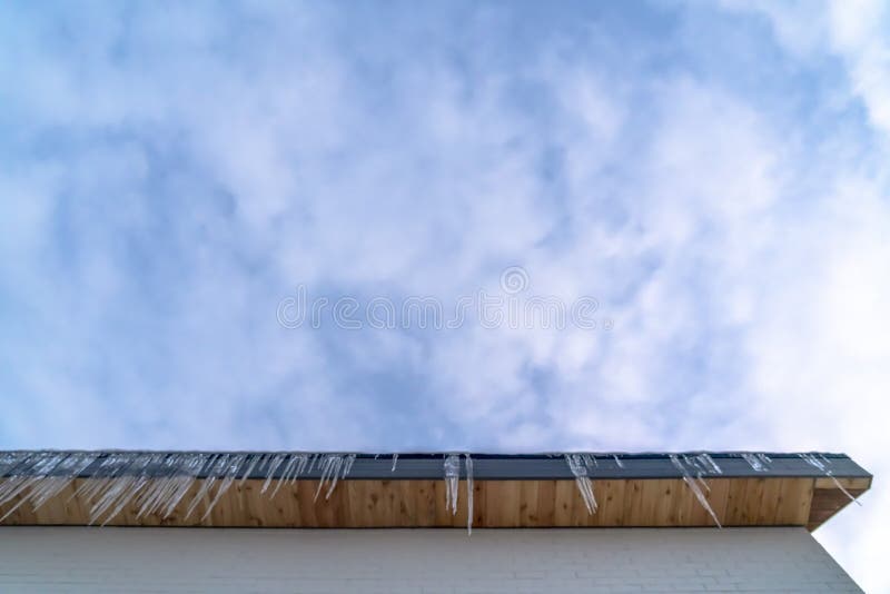 Roof with Sharp Icicles Against Cloudy Blue Sky Stock Photo - Image of ...