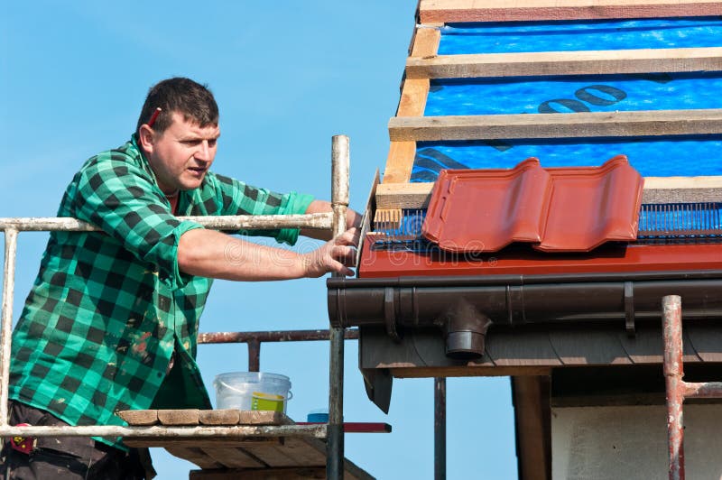 Male roofer fitting tiles stock image. Image of building - 20843229