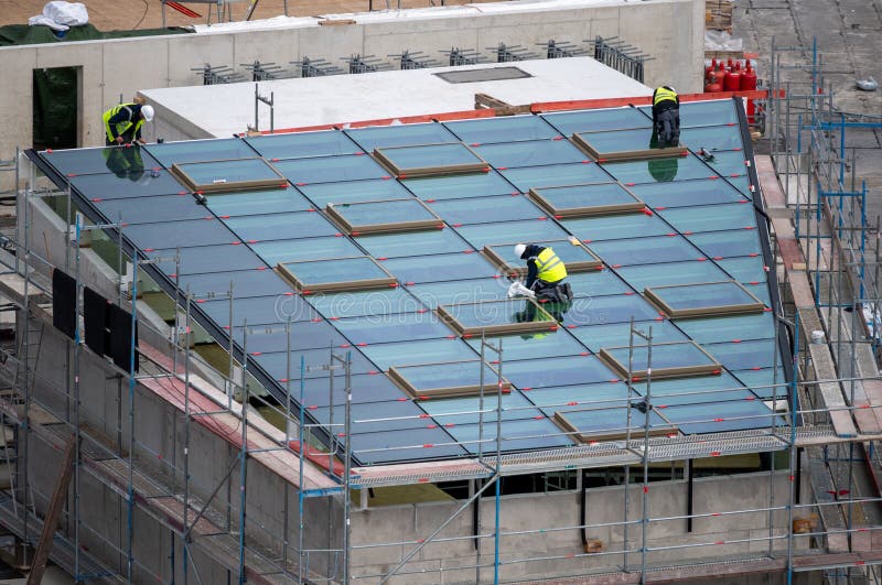 Roofer Installing Windows for a Light Well on the Roof of a Commercial ...