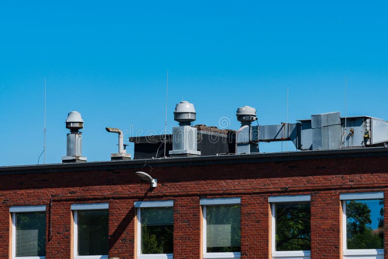 Rooftop Ventilation Structures on a Red Brick Building Under Clear Sky ...