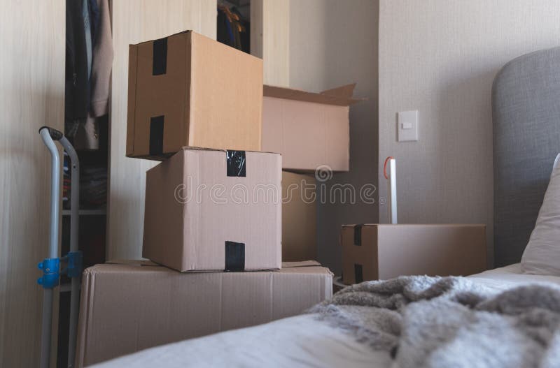 A Room with a Bed and a Stack of Boxes. New Home Concept. Stock Image ...
