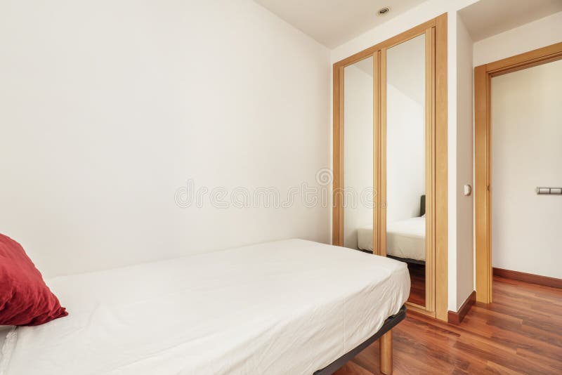 A Room with a Small Bed without a Bedspread and a Wardrobe Stock Image ...