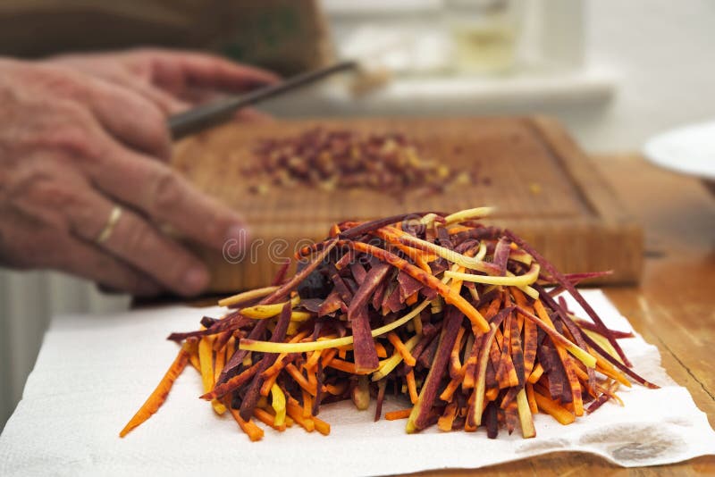 Root Vegetables Cut into Strips, Blurred Hands and Cutting Board Stock ...