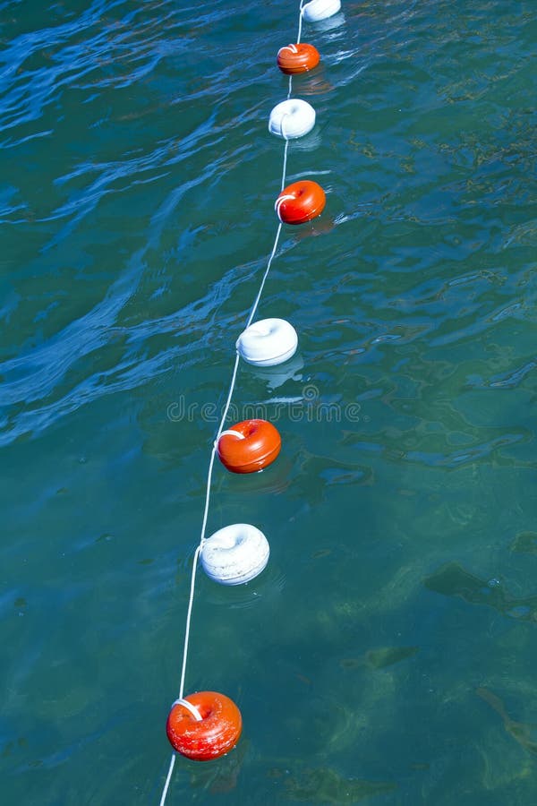 Rope with Buoys Above the Surface of the Blue Water. Bounding Buoys at ...