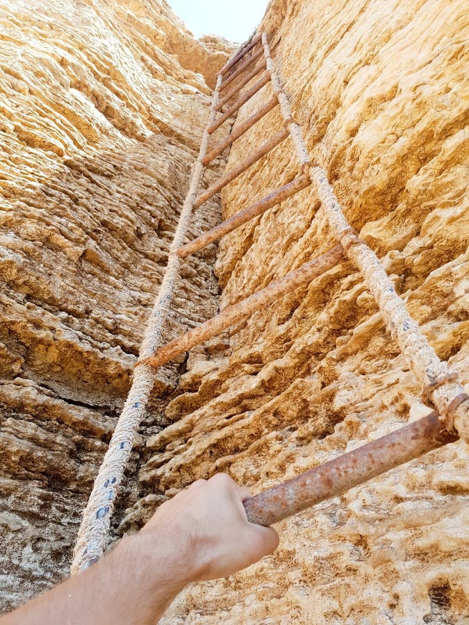 Rope Ladder on a Cliff, it Holds the Hand of a Man. Sunny Cloudless ...