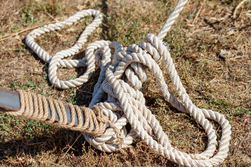 A Rope is Tied To a Pole and is Laying on the Ground Stock Photo ...