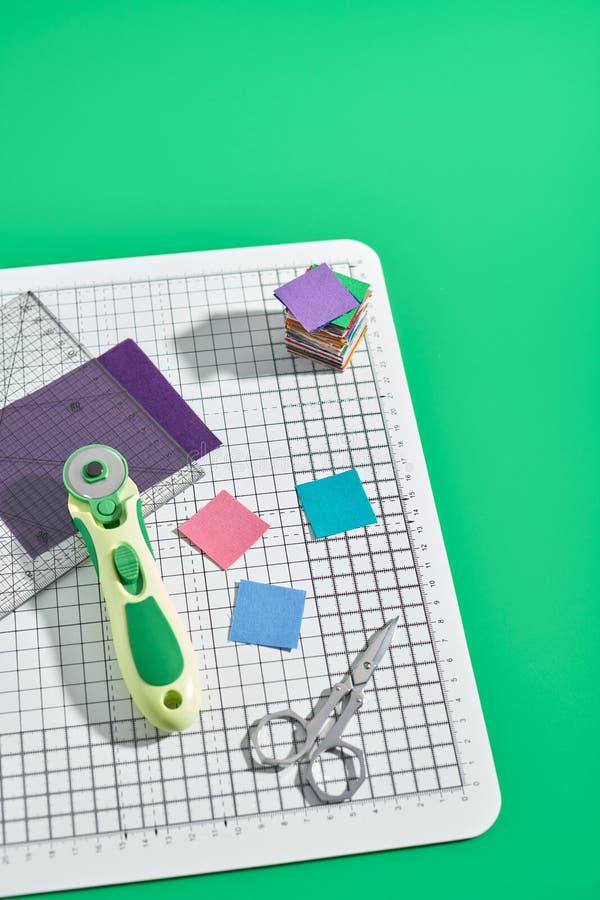 Rotary Cutter, Ruler, Bright Square Pieces of Fabric, Stack of Bright ...