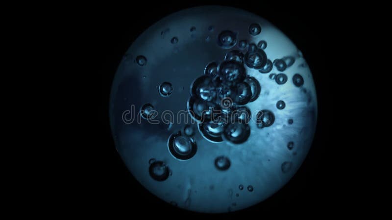 Rotating Blue Sphere with Air Bubbles Inside on a Black Background ...