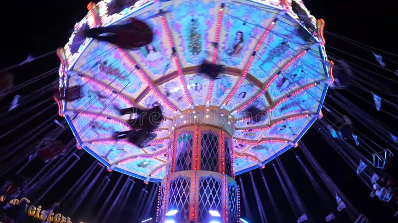Rotating Lighted Chain Carousel Chairoplane at a Fun Fair at Night with ...