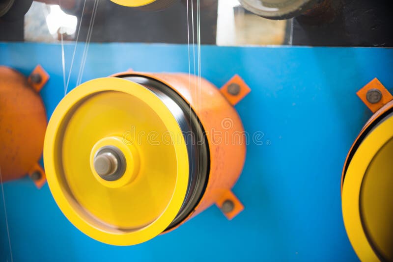 A Rotating Wheel Rewinds a Thin Silver Wire. Stock Image - Image of ...