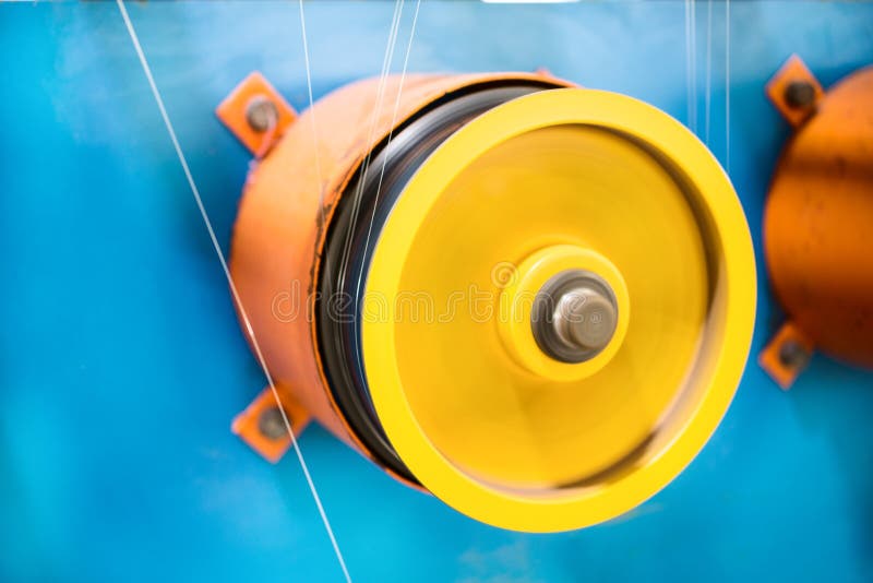 A Rotating Wheel Rewinds a Thin Silver Wire. Stock Image - Image of ...
