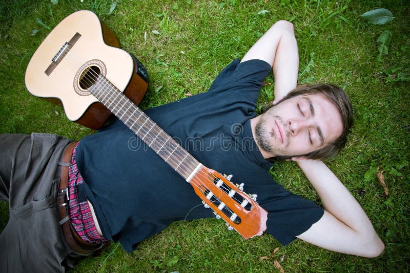 Rough Country Guy Laying in the Grass Stock Photo - Image of guitar ...