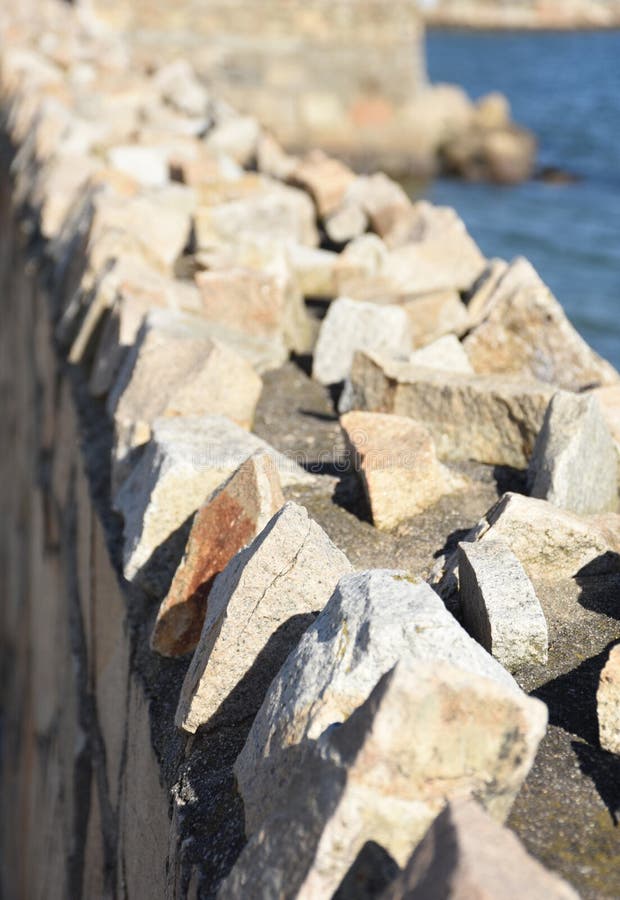 Rough and Jagged Rocks Along a Retaining Wall Stock Photo - Image of ...