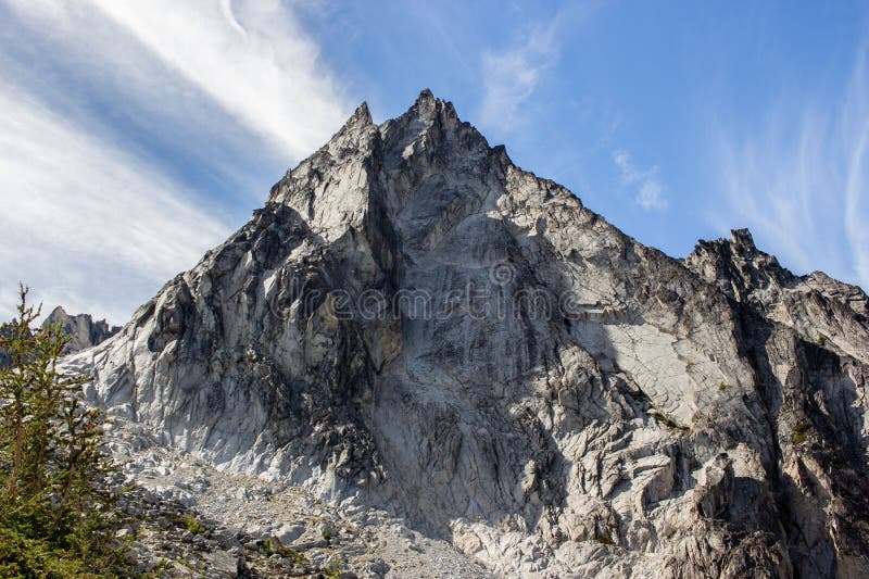 Rough Rocky Mountain Peak Under a Cloudy Blue Sky Stock Image - Image ...