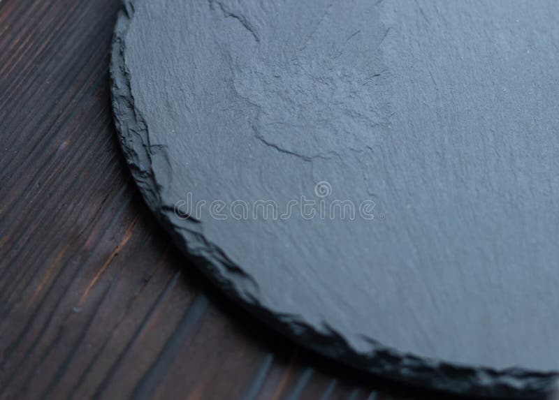 Round Black Slate Board on Wooden Table Stock Image - Image of board ...