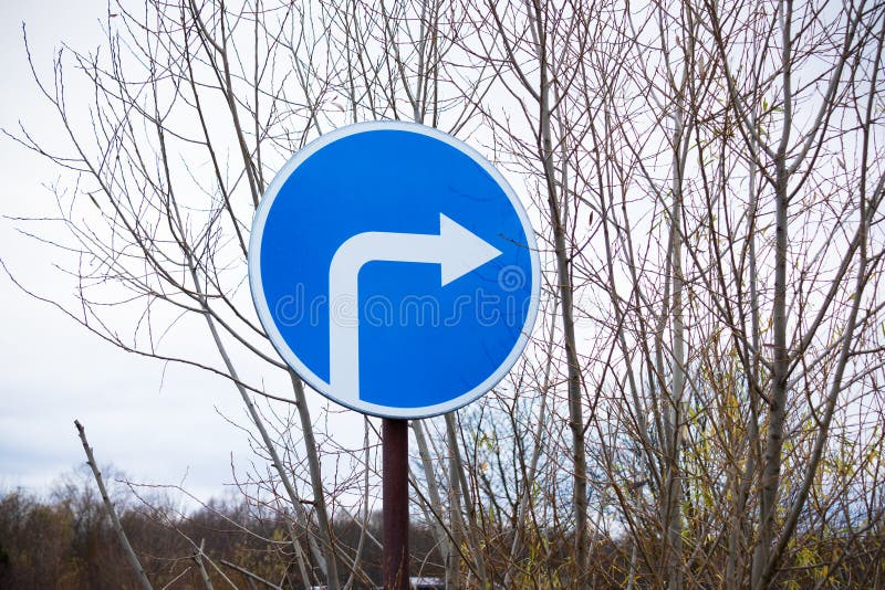 Round Blue Road Sign with White Arrow Turn Right Against the Backdrop ...