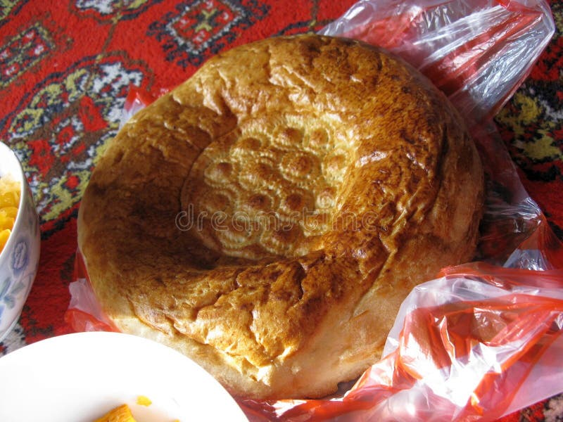 Round Bread Loaf with Patterned Top Wrapped in Plastic on a Patterned ...