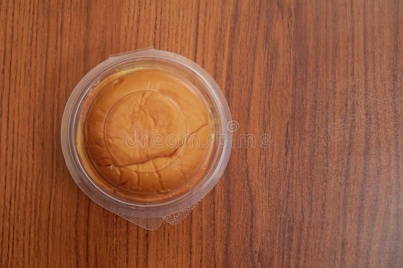 Round Butter Bun in Plastic Packaging on a Wooden Table Surface, Top ...