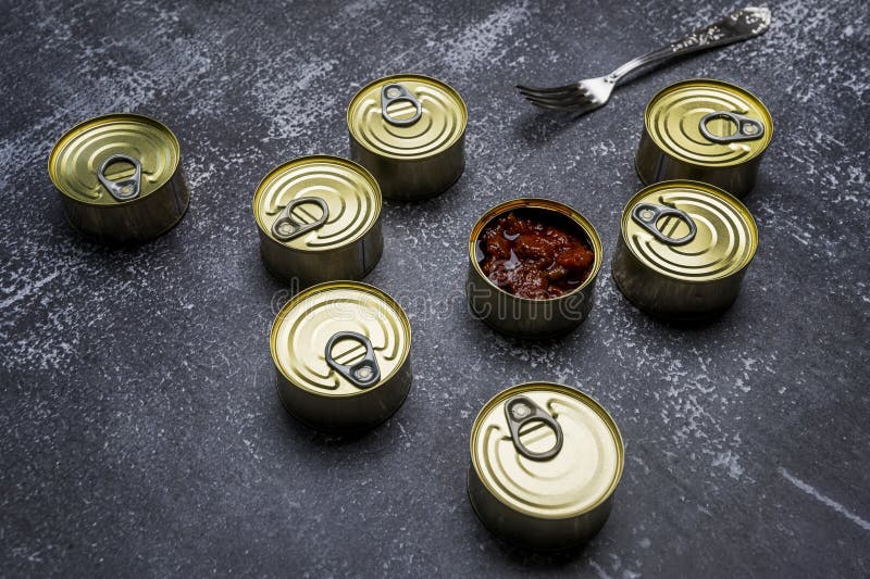 Round Cans of Canned Fish in Sauce with One Open and a Fork To Empty it ...