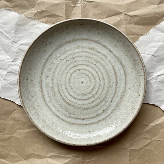 Round Ceramic Plate with Concentric Circle Patterns Sits on Crumpled ...