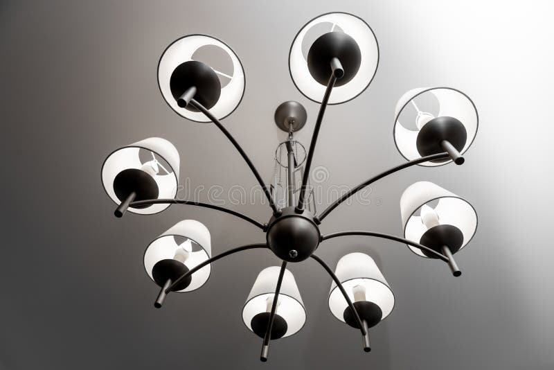 A Round Chandelier of Several Lamps Against a Light Ceiling, Full Frame ...