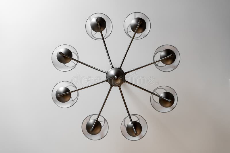 A Round Chandelier of Several Lamps Against a Light Ceiling, Full Frame ...