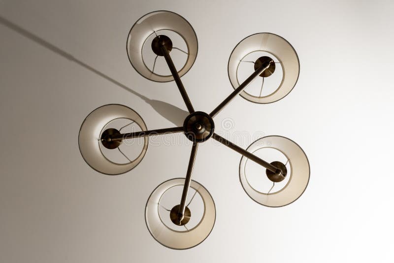 A Round Chandelier of Several Lamps Against a Light Ceiling, Full Frame ...