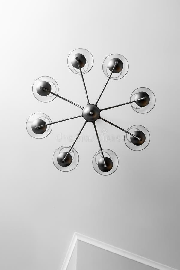 A Round Chandelier of Several Lamps Against a Light Ceiling, Full Frame ...