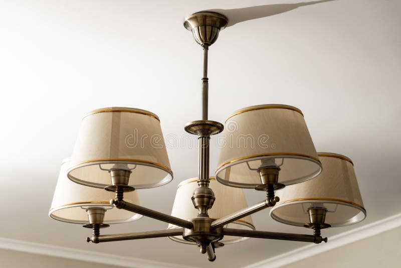 A Round Chandelier of Several Lamps Against a Light Ceiling, Full Frame ...