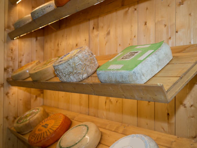 Round Cheese Shapes Displayed on a Wooden Shelf of a Store Stock Photo ...