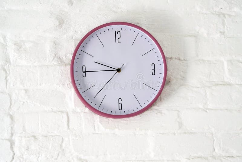 Round Clock with Arrows and Numbers on a White Brick Wall. Stock Image ...