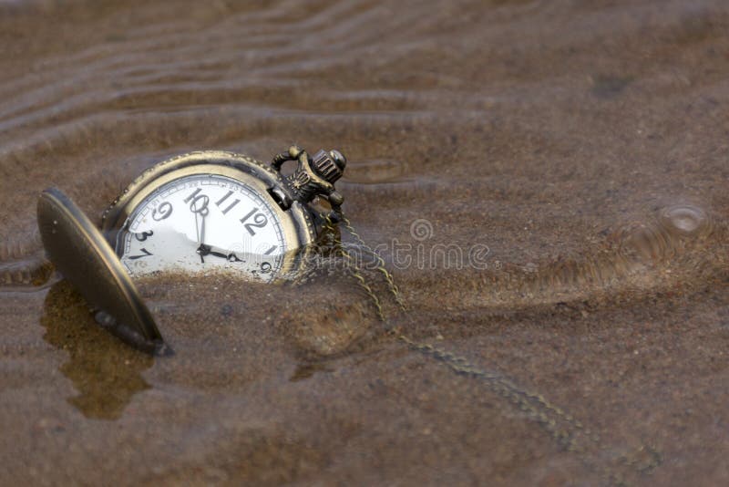 Round Clock with Hands Lying on the Wet Sand Under Water Stock Photo ...