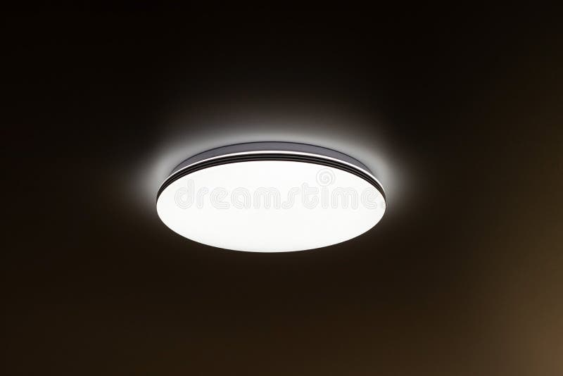 Round Flat Lamp Shines on the Ceiling in the Dark Stock Image - Image ...