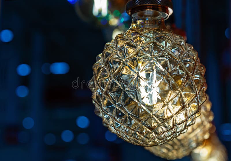 Round Light Bulb with Dark Faceted Glass on a Blue Background Stock ...