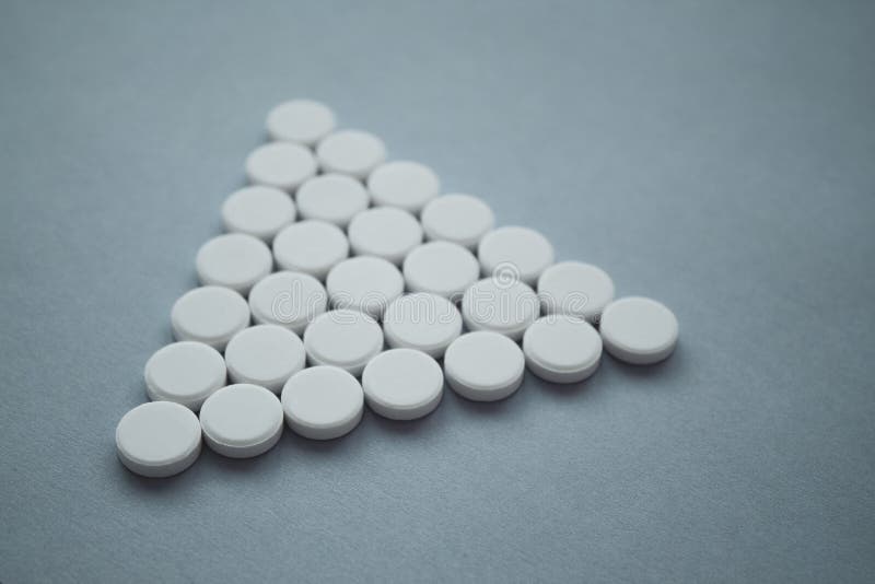 Round Medicinal Tablets in the Shape of a Triangle on a Blue Background ...