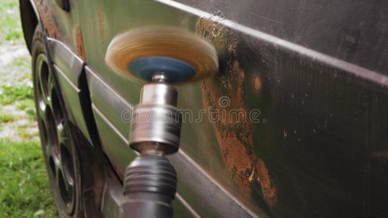 A Round Metal Brush in the Hands of a Craftsman Removes Rust from a Car ...