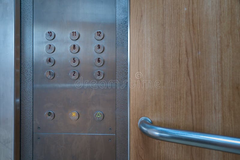 Round Metallic Buttons on an Elevator Control Panel with Wooden ...