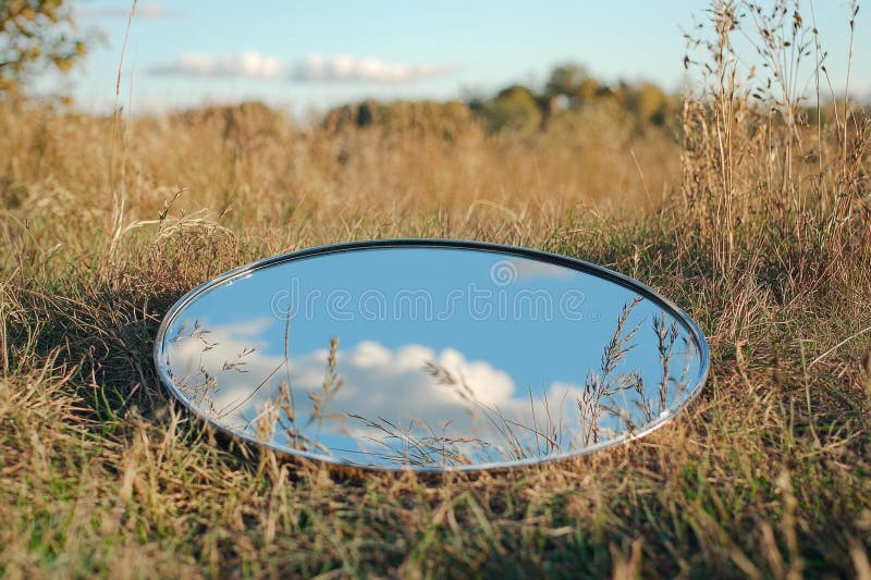 Round Mirror Reflecting the Blue Cloudy Sky Laying in a Dry Grass Field ...