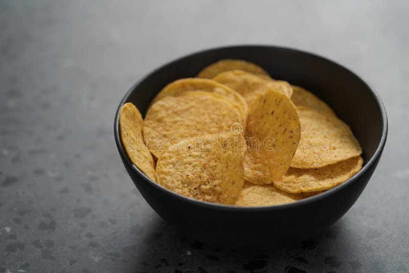 Round Nachos in Black Ceramic Bowl on Concrete Background with Copy ...