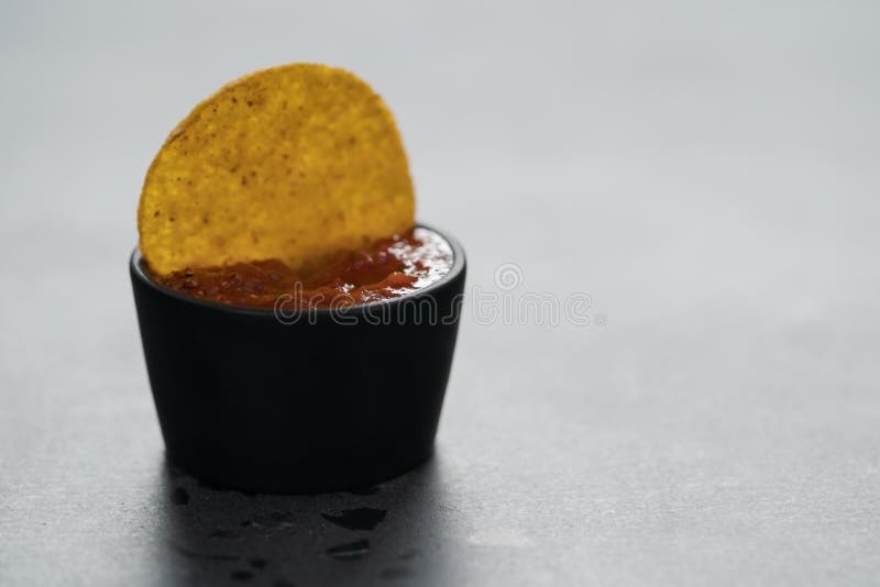 Round Nachos in Black Ceramic Bowl on Concrete Background with Red ...