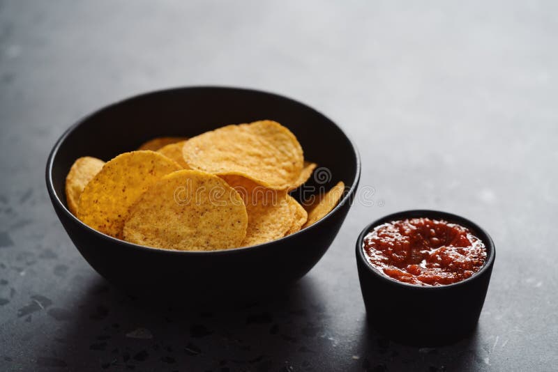 Round Nachos in Black Ceramic Bowl on Concrete Background with Red ...