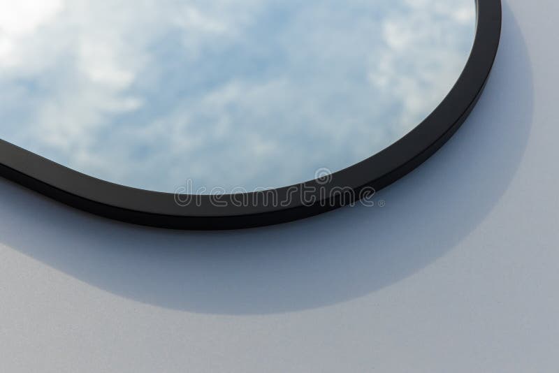 A Round or Oval Mirror with a Reflection of the Blue Sky and White ...
