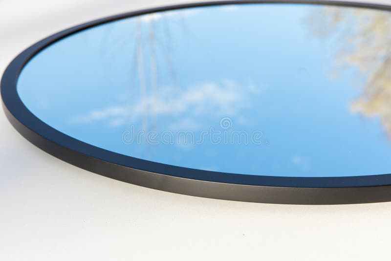 A Round or Oval Mirror with a Reflection of the Blue Sky and White ...