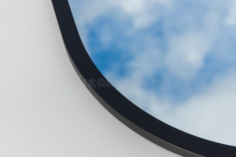 A Round or Oval Mirror with a Reflection of the Blue Sky and White ...