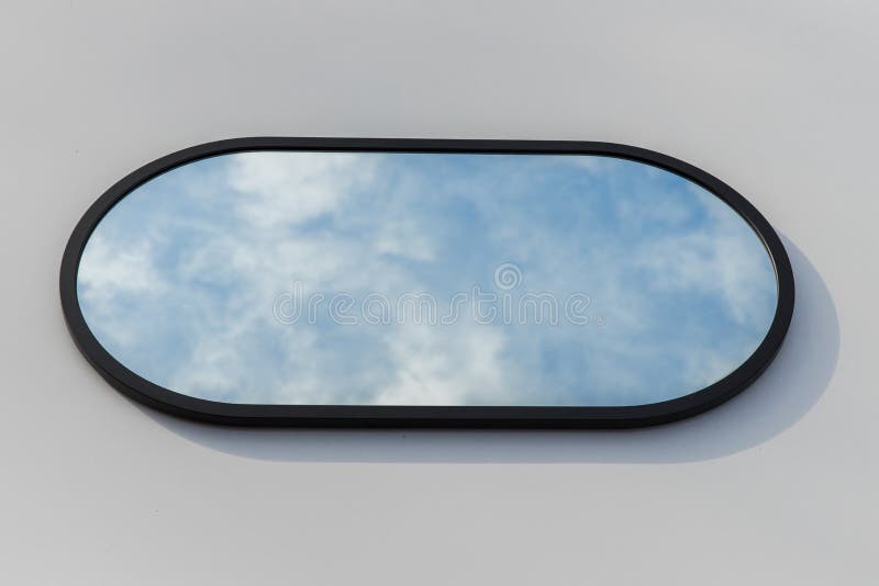 A Round or Oval Mirror with a Reflection of the Blue Sky and White ...
