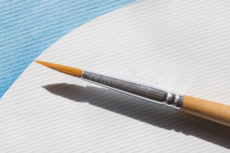 Round Paint Brush Laying on White Paper with Blue Stroke Stock Photo ...