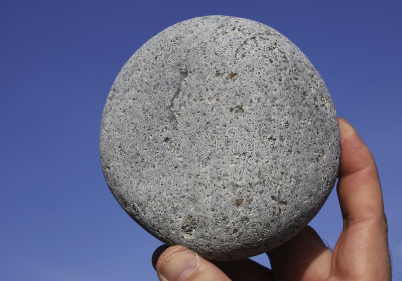 Round Pebble Stone Hold in Male Hand on Blue Sky Background Stock Image ...