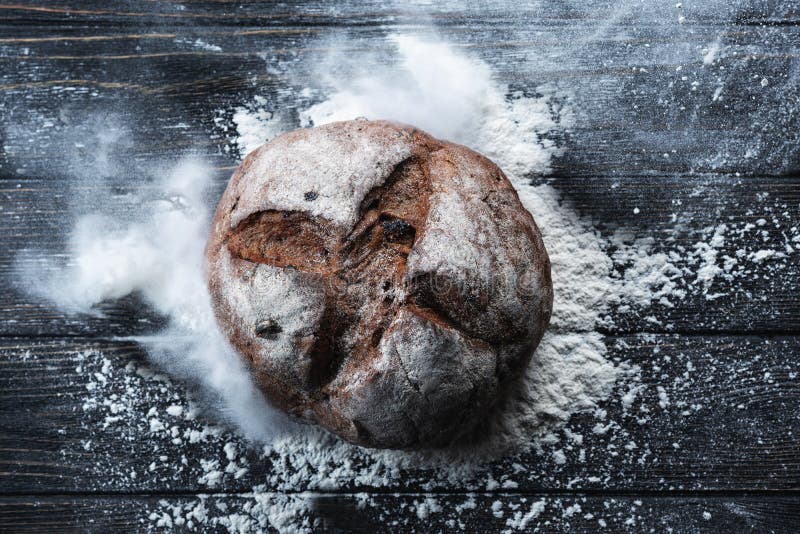 Round Rye Bread with Flour on a Black Table, Top View Stock Photo ...